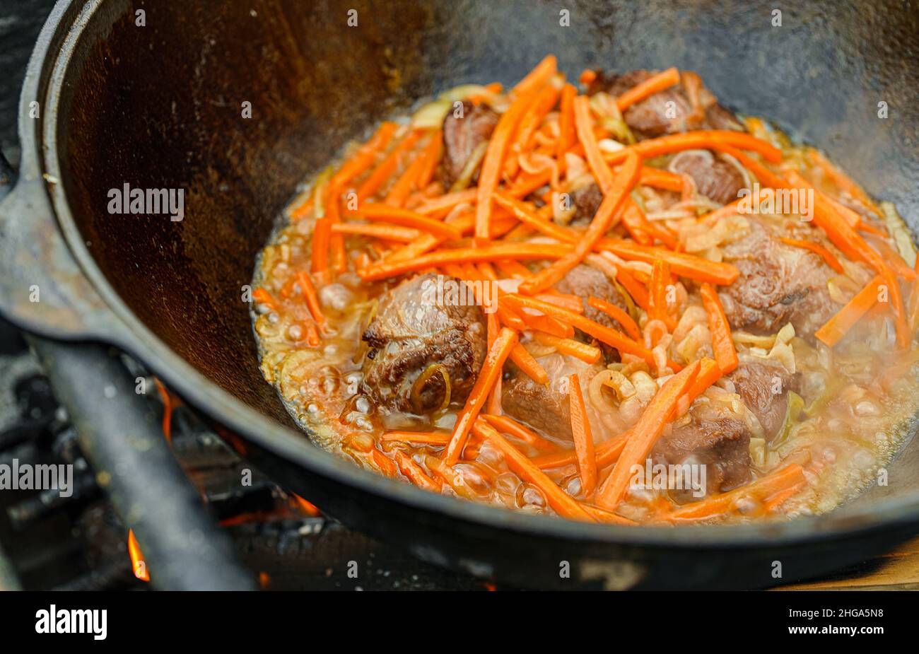 Meat is cooked in cauldron on fire. Step by step cooking of Pilaf Stock ...