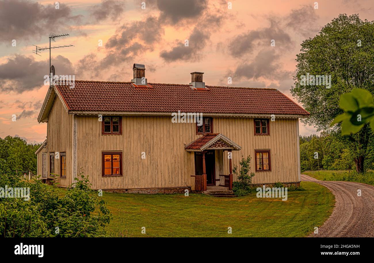 Ancient farmhouse in the sunset with yellow light in the windows ...