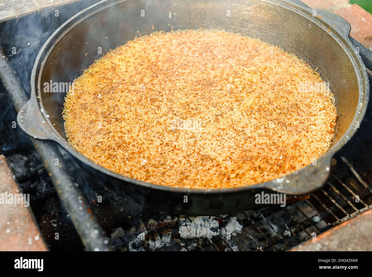 Rice is cooked in cauldron on fire. Step by step cooking of Pilaf Stock ...