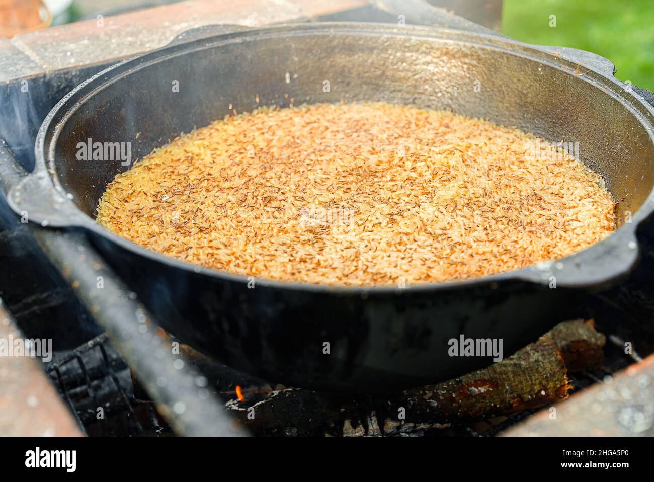 Rice is cooked in cauldron on fire. Step by step cooking of Pilaf Stock ...