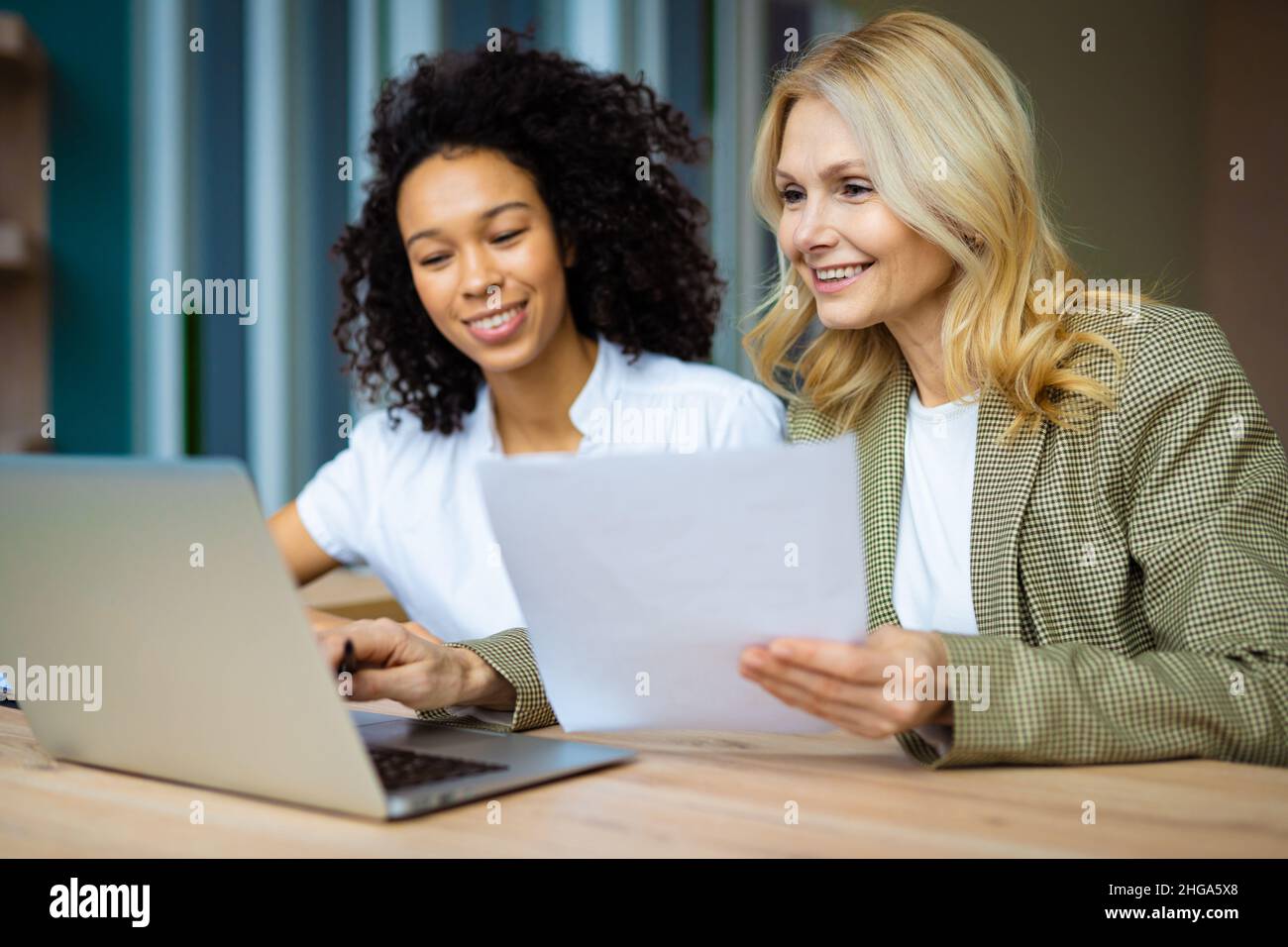 Beautiful adult businesswomen with elegant dress sitting at computer ...