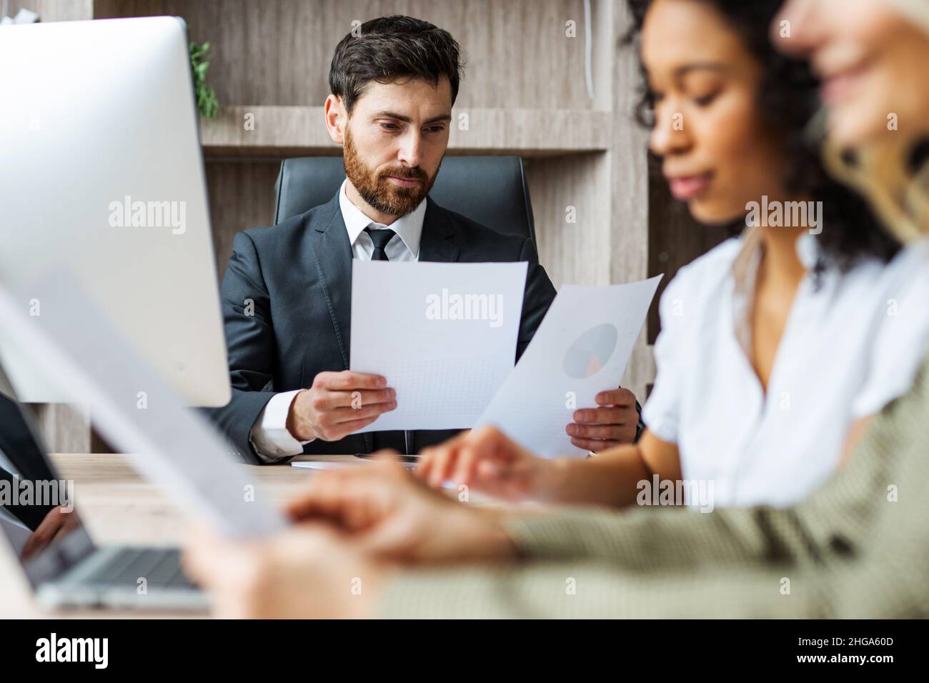 Multiracial group of businesspeople with elegant dress sitting at ...