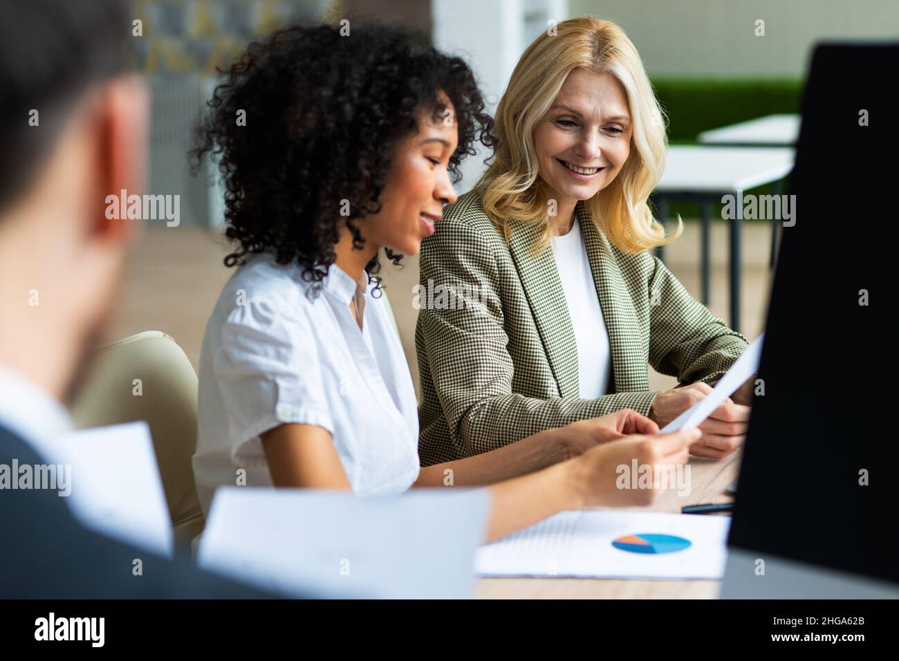 Multiracial group of businesspeople with elegant dress sitting at ...