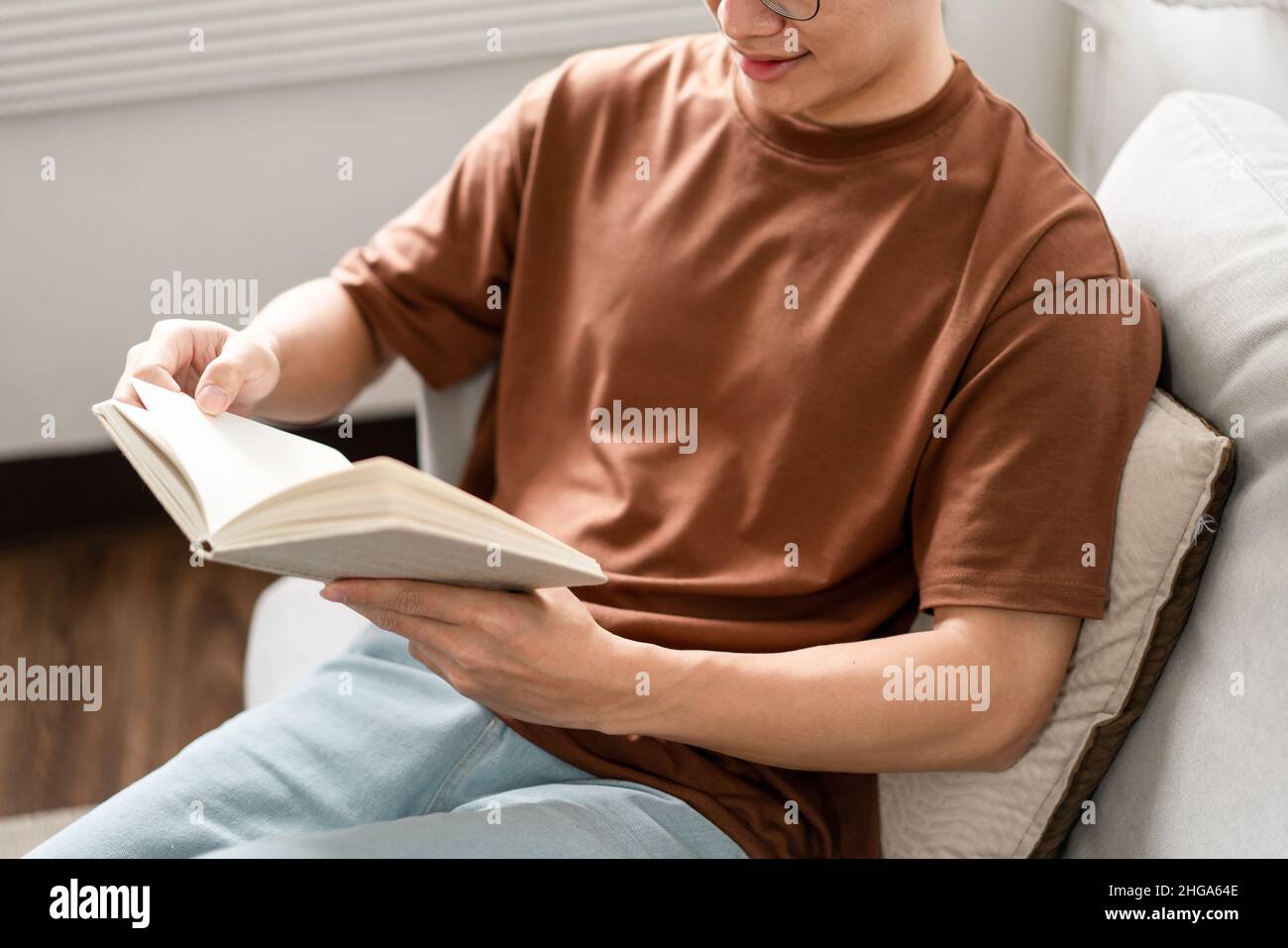 Technology Concept The male with his glasses sitting on the grey sofa ...