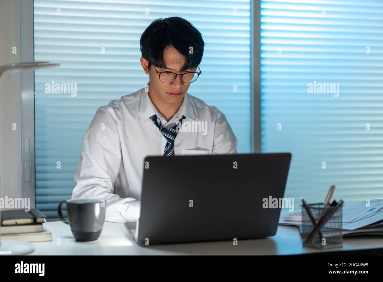 Overwork Concept The man sitting at his desk and focusing on working ...