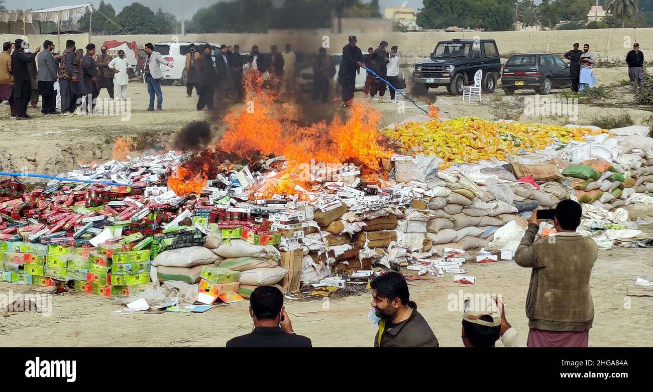 View of destroying liquor bottles and burning pile of confiscated drugs ...