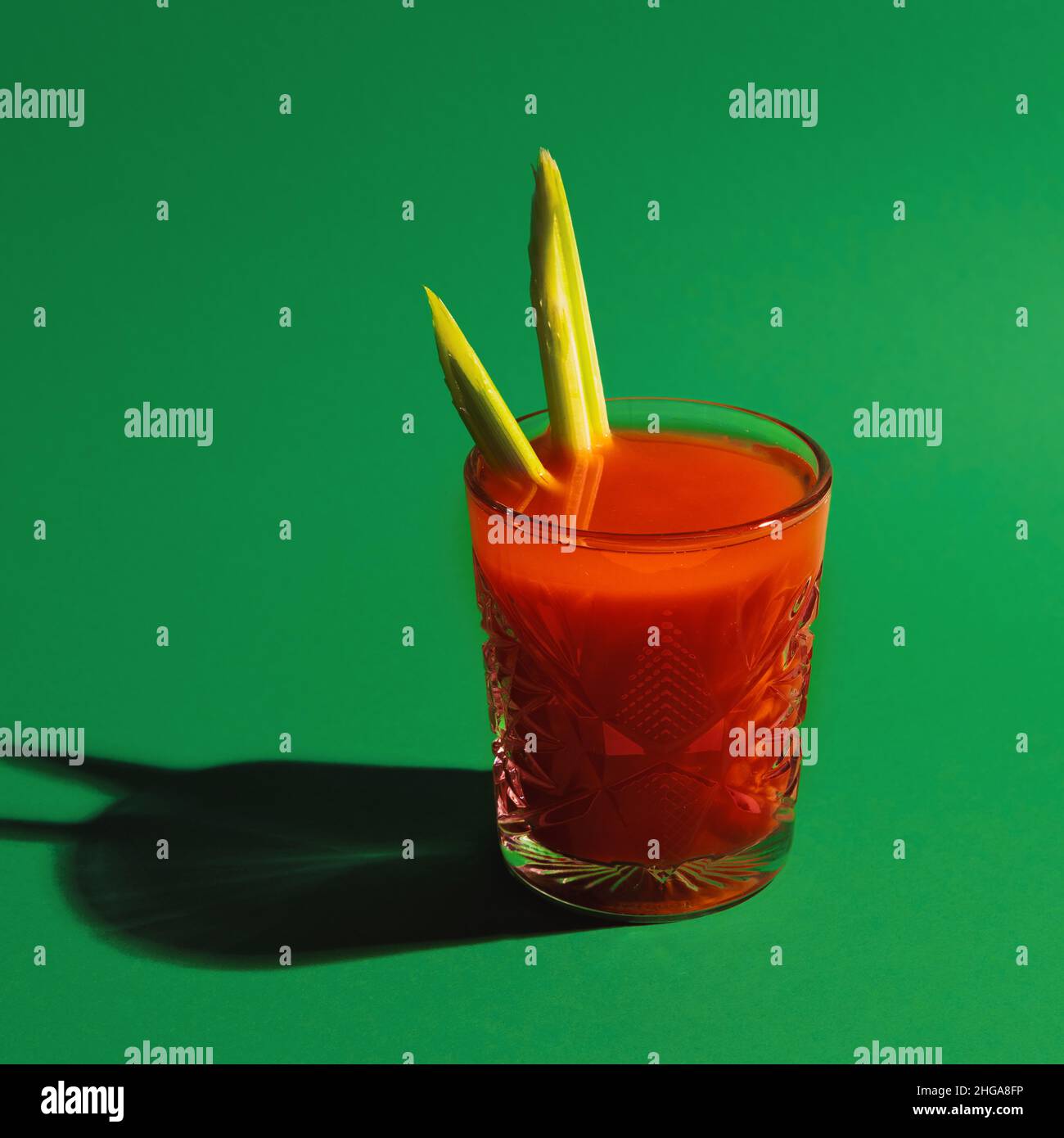 Glass with cocktail bloody mary isolated on bright green neon ...