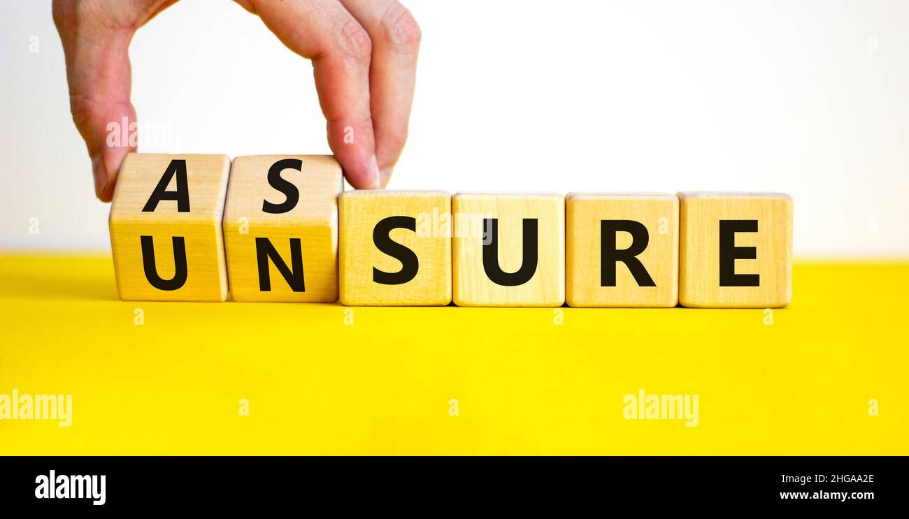 Assure or unsure symbol. Businessman turns wooden cubes and changes the ...
