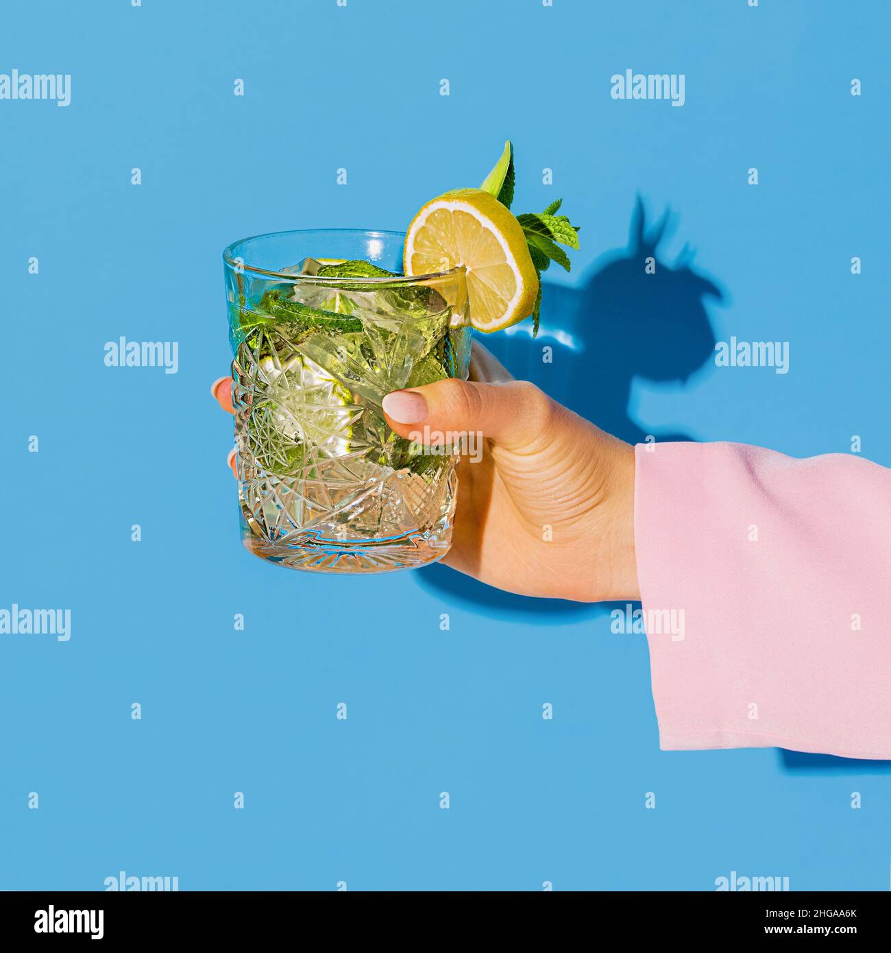 Female hand holding glass with cocktail mojito with lemon isolated on ...