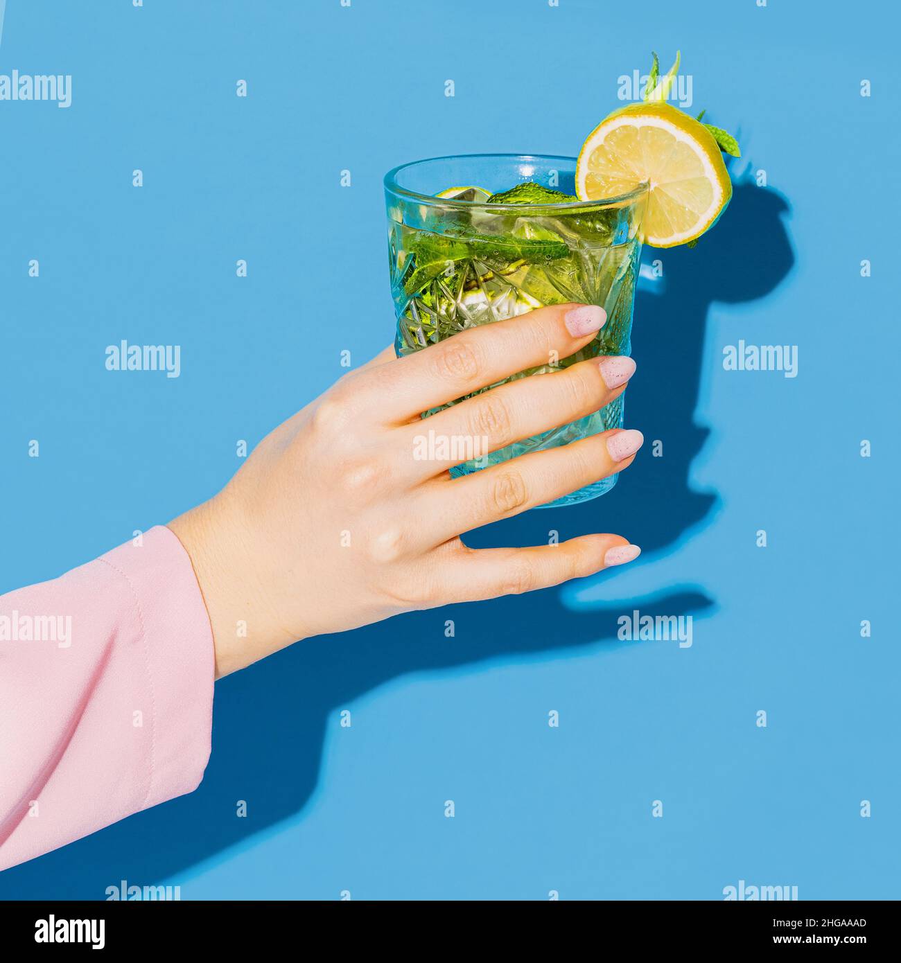 Female hand holding glass with cocktail mojito with lemon isolated on ...