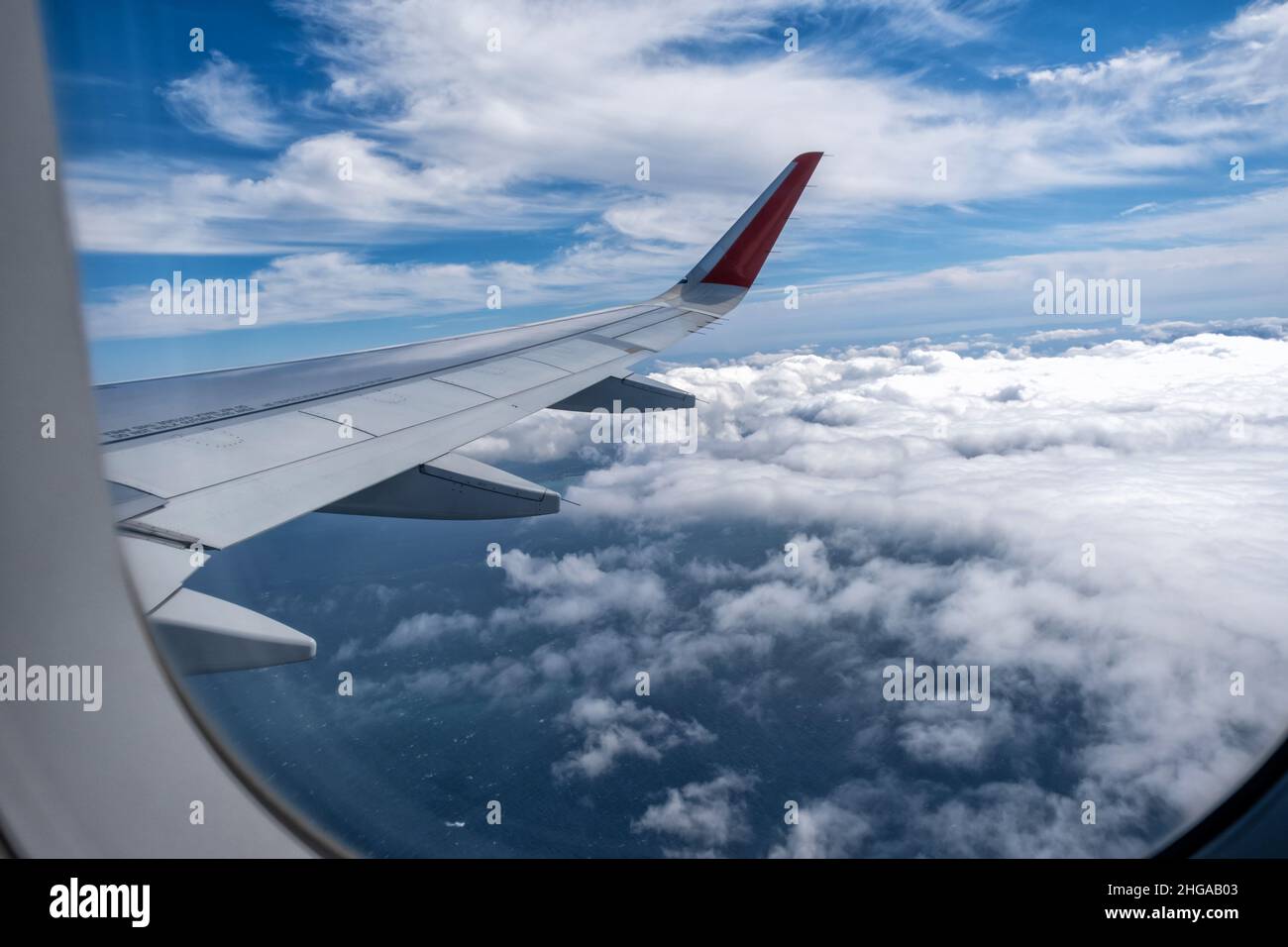 Classic image through aircraft window onto wing. Flight view over sea ...