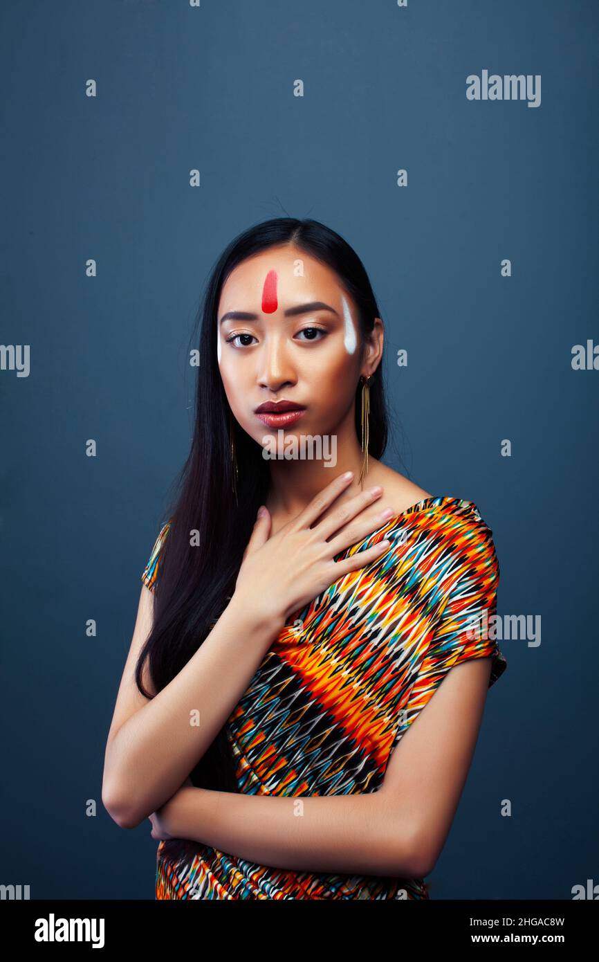 young pretty south asian girl posing in studio on grey background ...