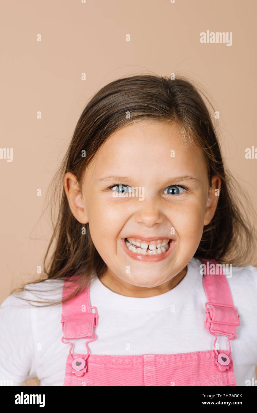Portrait of female kid with scary frightening grinning forced smile ...