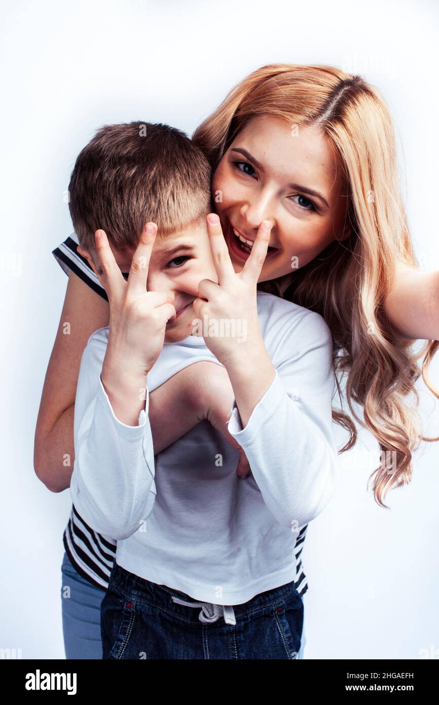 young modern blond mother with cute son together happy smiling family posing cheerful on white ...