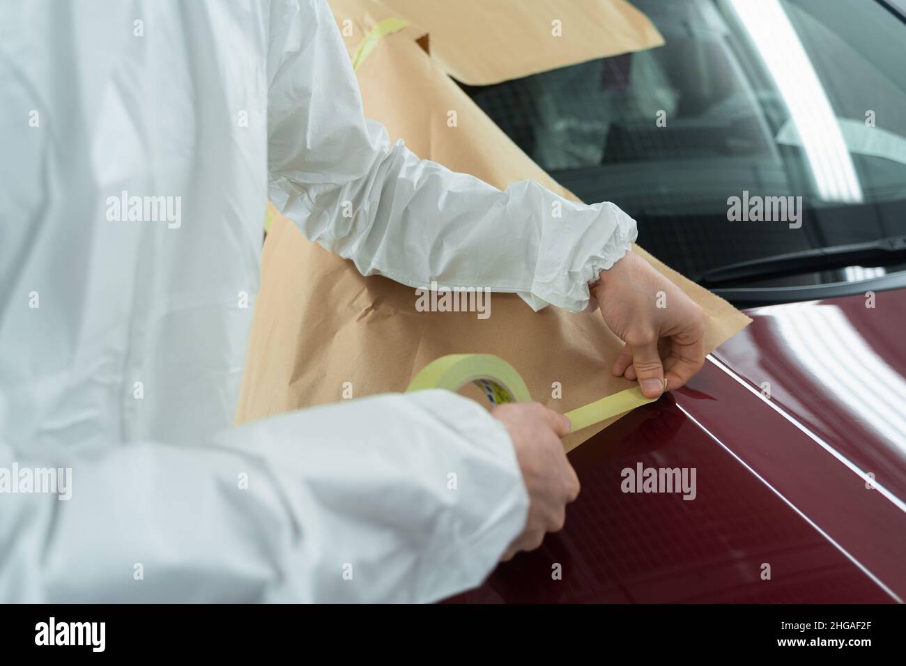 Close-up view of auto painter's hands who covering a car body before ...