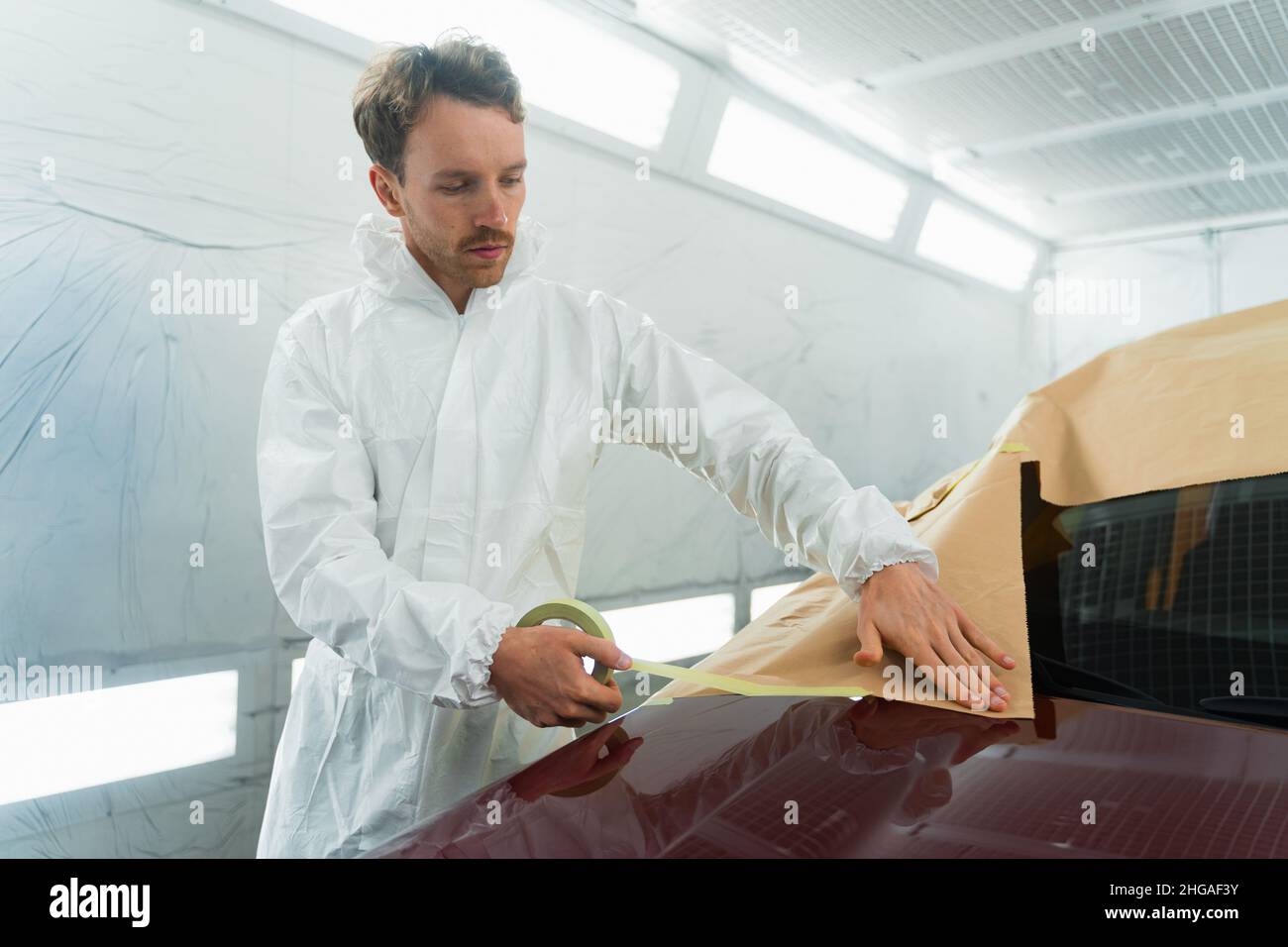 Auto painter covering car body before painting or polishing with ...