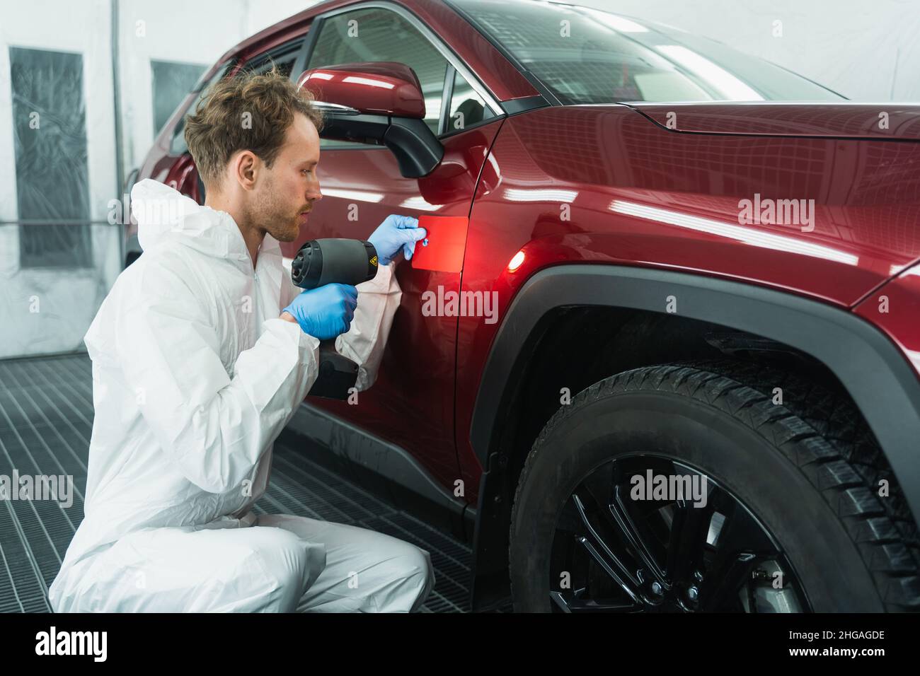 Professional auto painter matches car paint color with lamp and samples ...