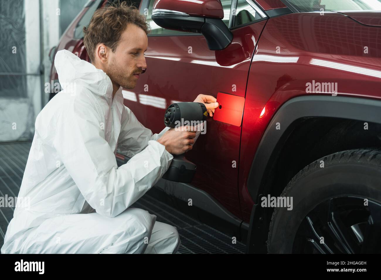 Professional auto painter matches car paint color with lamp and samples ...