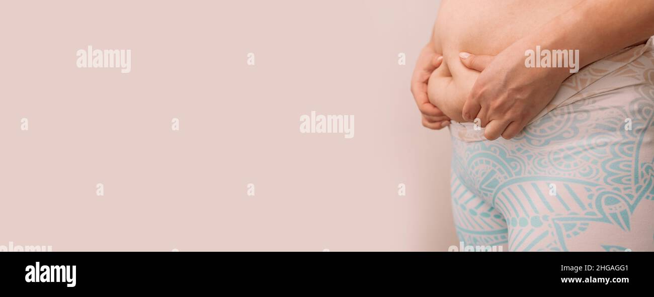 Fat woman using her hands to squeeze out excess fat that is isolated on ...