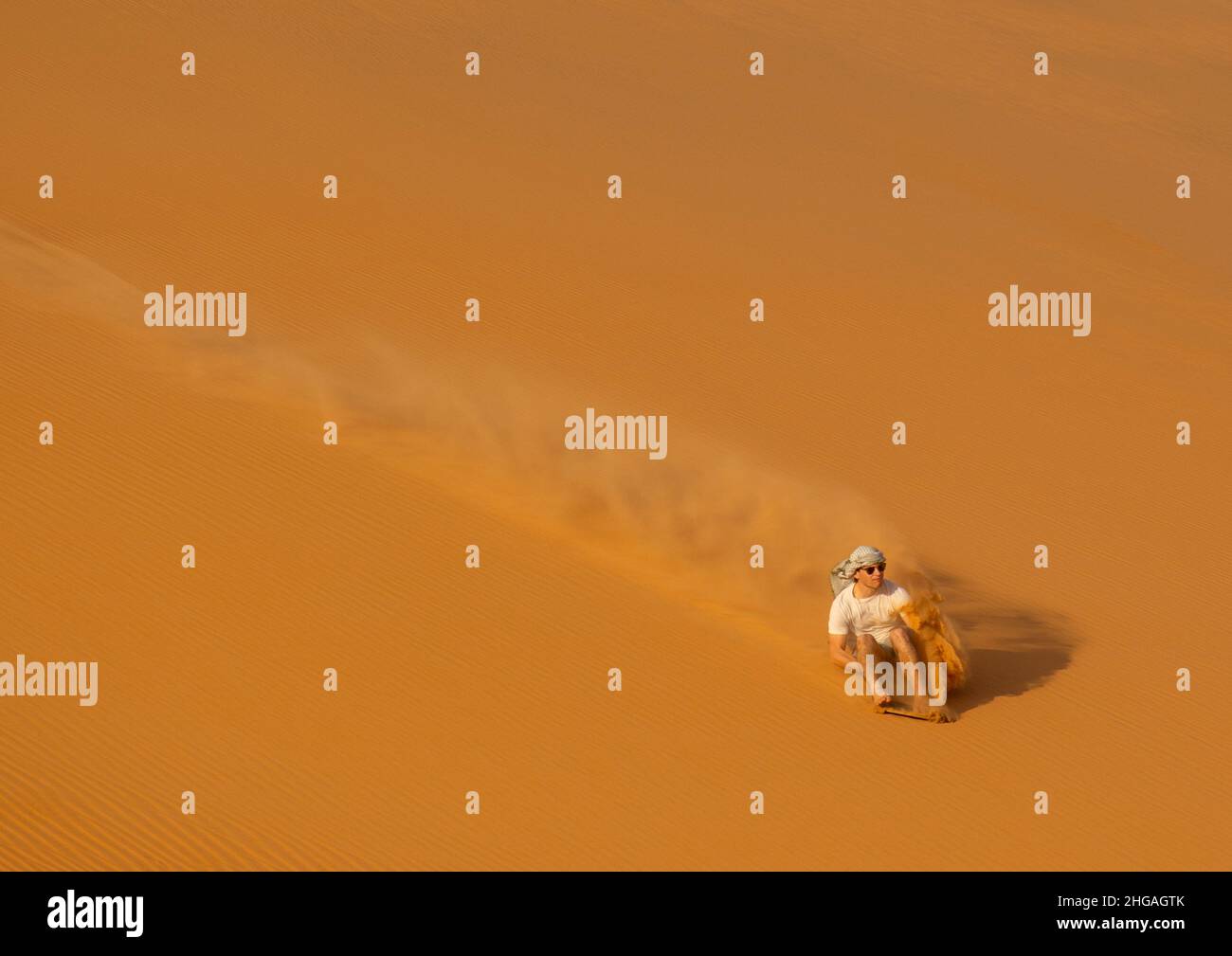 Tourist making sandboarding in the Rub al Khali dunes desert, Najran ...