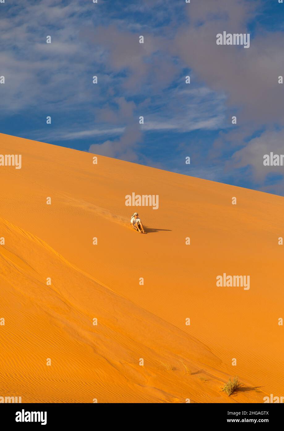 Tourist making sandboarding in the Rub al Khali dunes desert, Najran ...