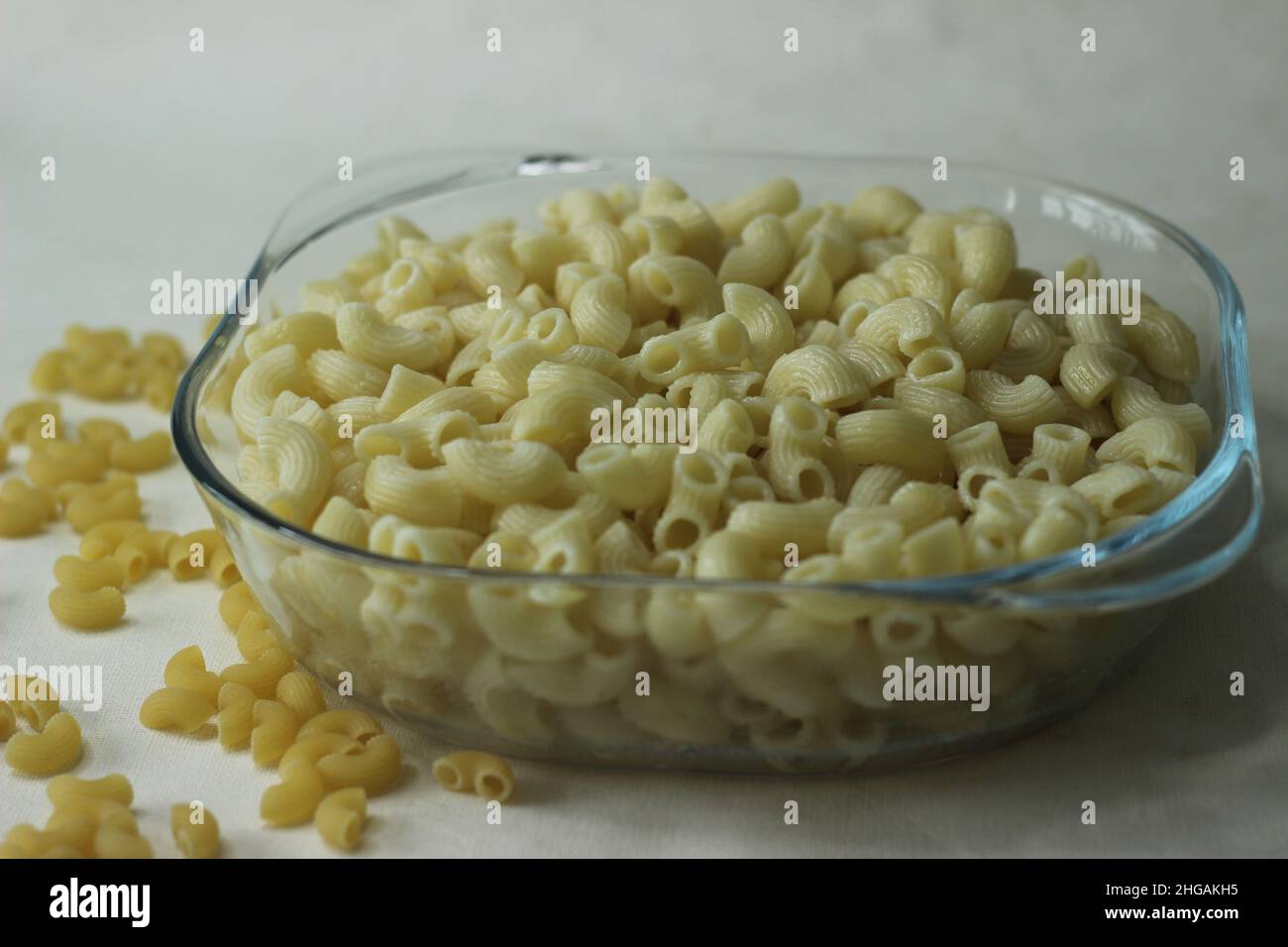 Boiled macaroni pasta inside a square glass bowl. Shot on white ...