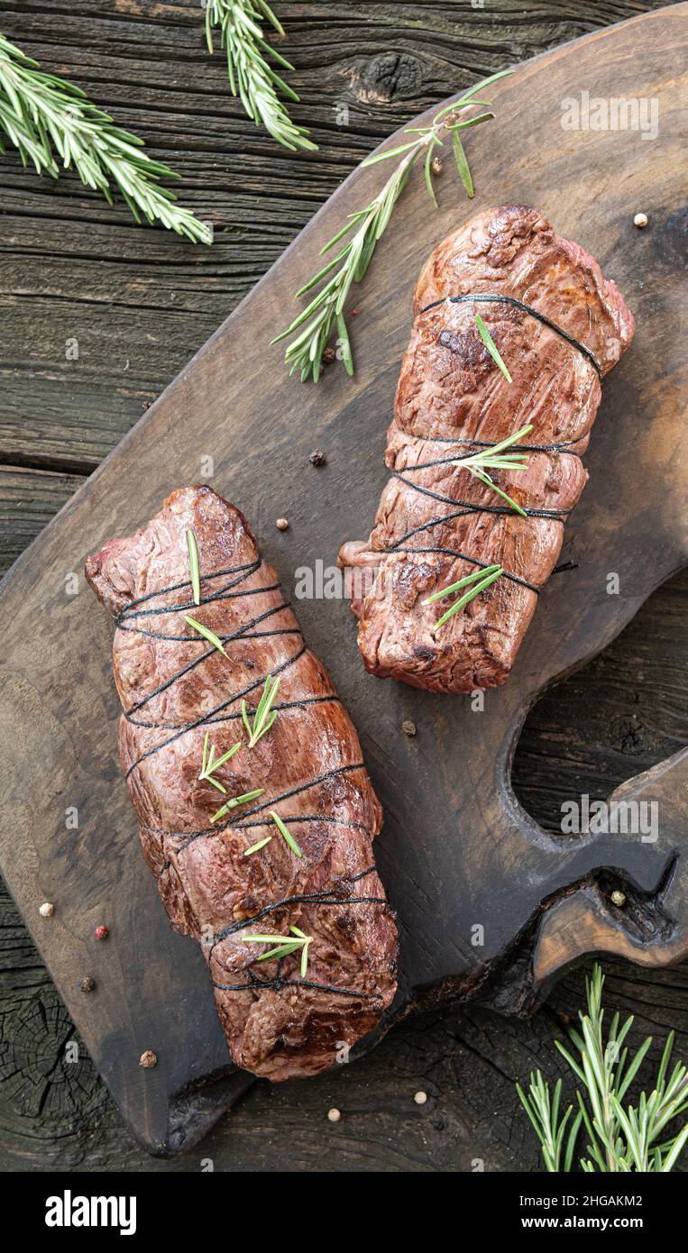Two portions of juicy freshly roasted beef tenderloin steaks tied up ...