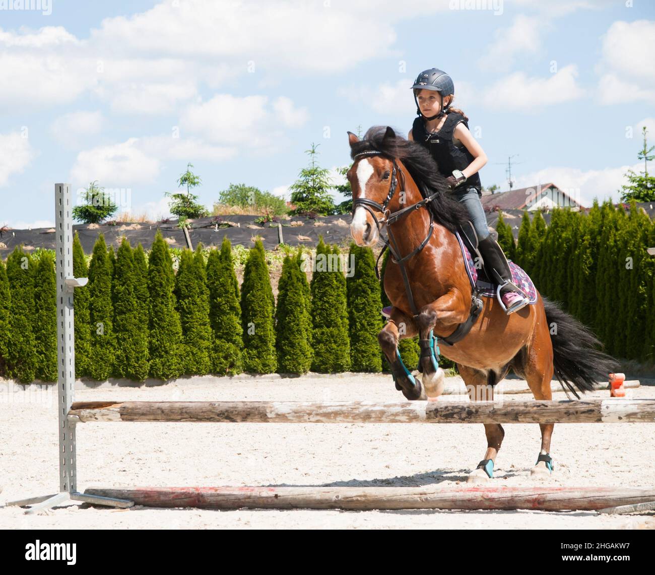 Young girl practising jumping over hurdle Stock Photo - Alamy