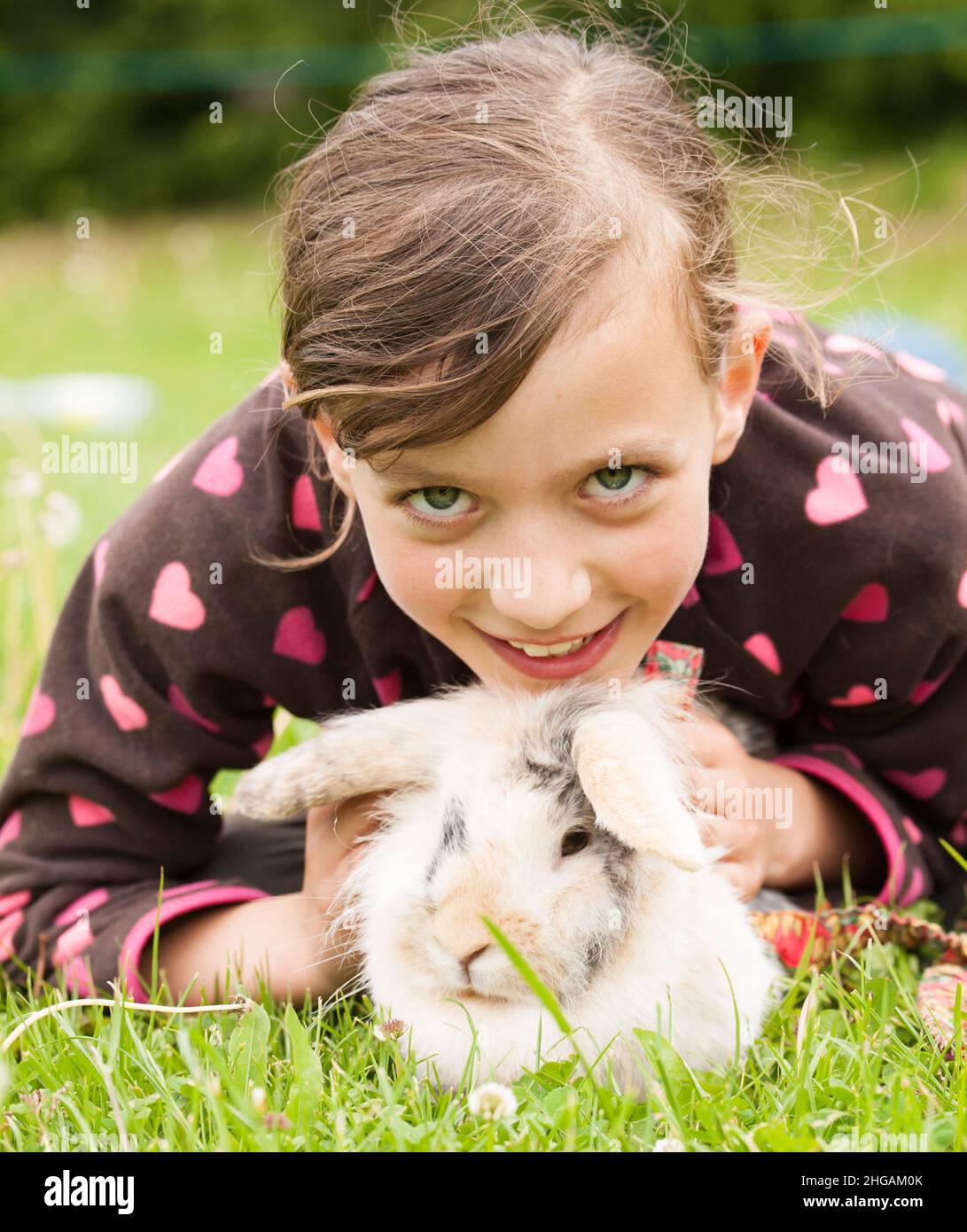 Young girl lying on meadow with her rabbit Stock Photo - Alamy