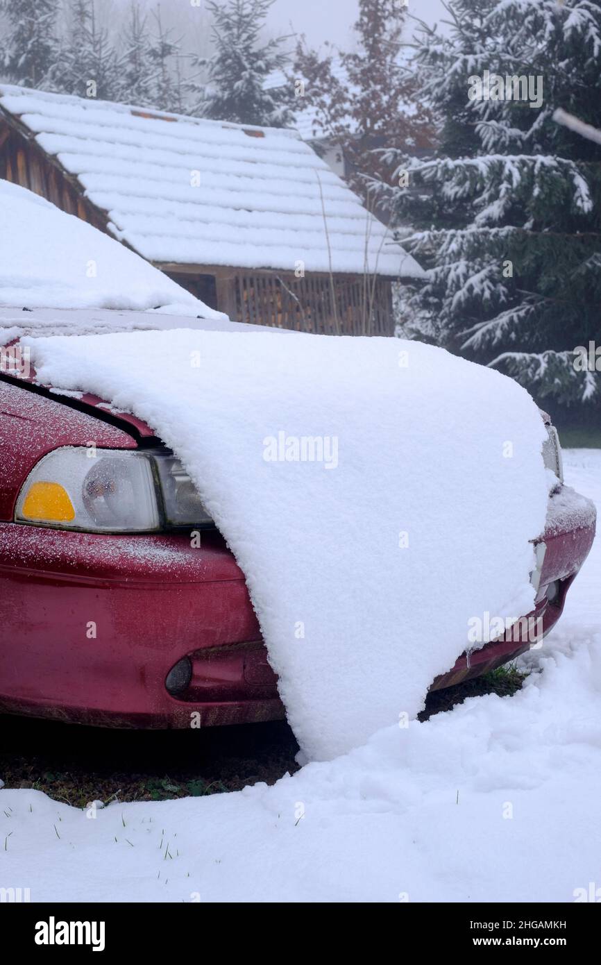 blanket of snow that has partially thawed and slid down car bonnet ...