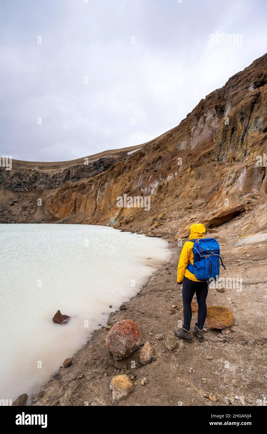 Hiker at the crater lake Viti in the crater of the volcano Askja, mountain massif Dyngjufjoell ...