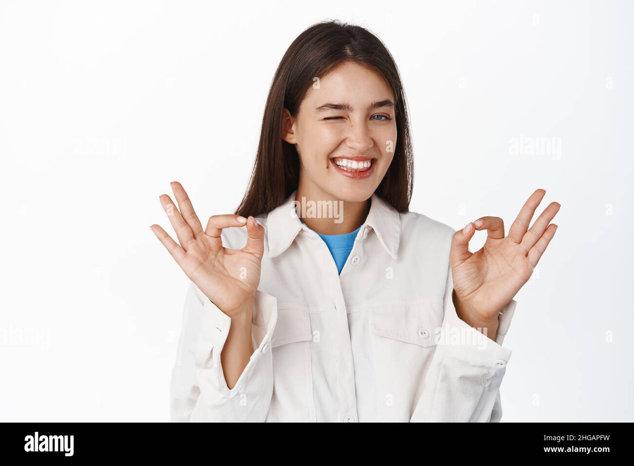 No problem. Smiling winking girl showing okay, ok signs and nod in ...