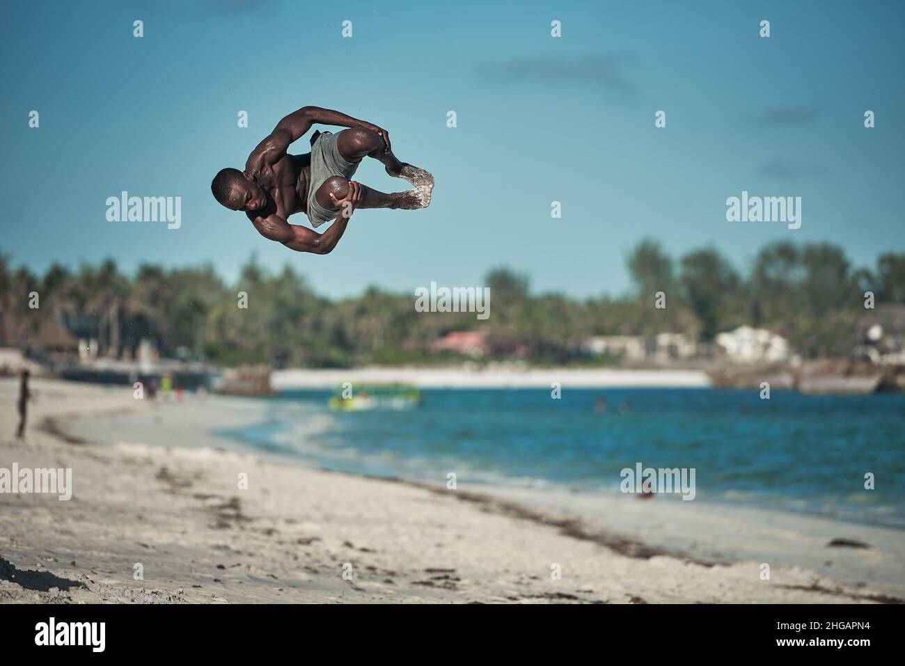 action acrobatioc jump of African young boy. Aerial rotation of am man ...