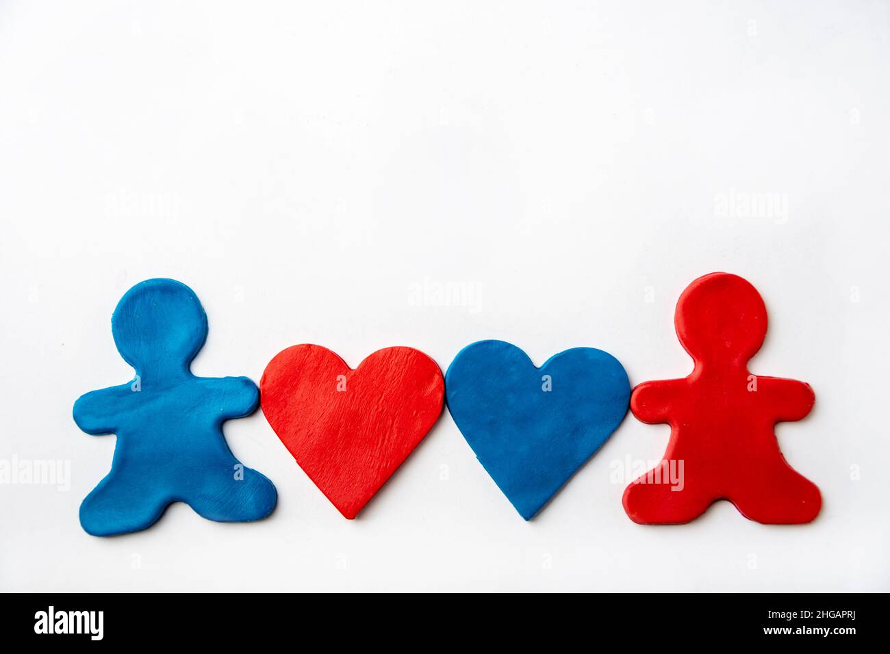 Blue and red plasticine people hold red and blue plasticine heart ...