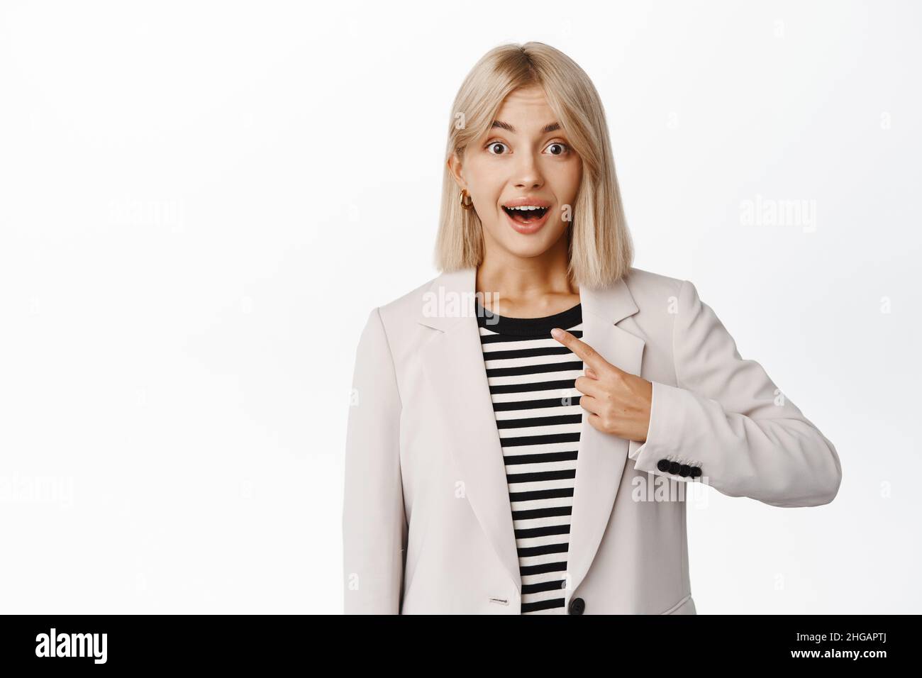 Portrait of corporate office girl looking surprised, pointing finger at ...