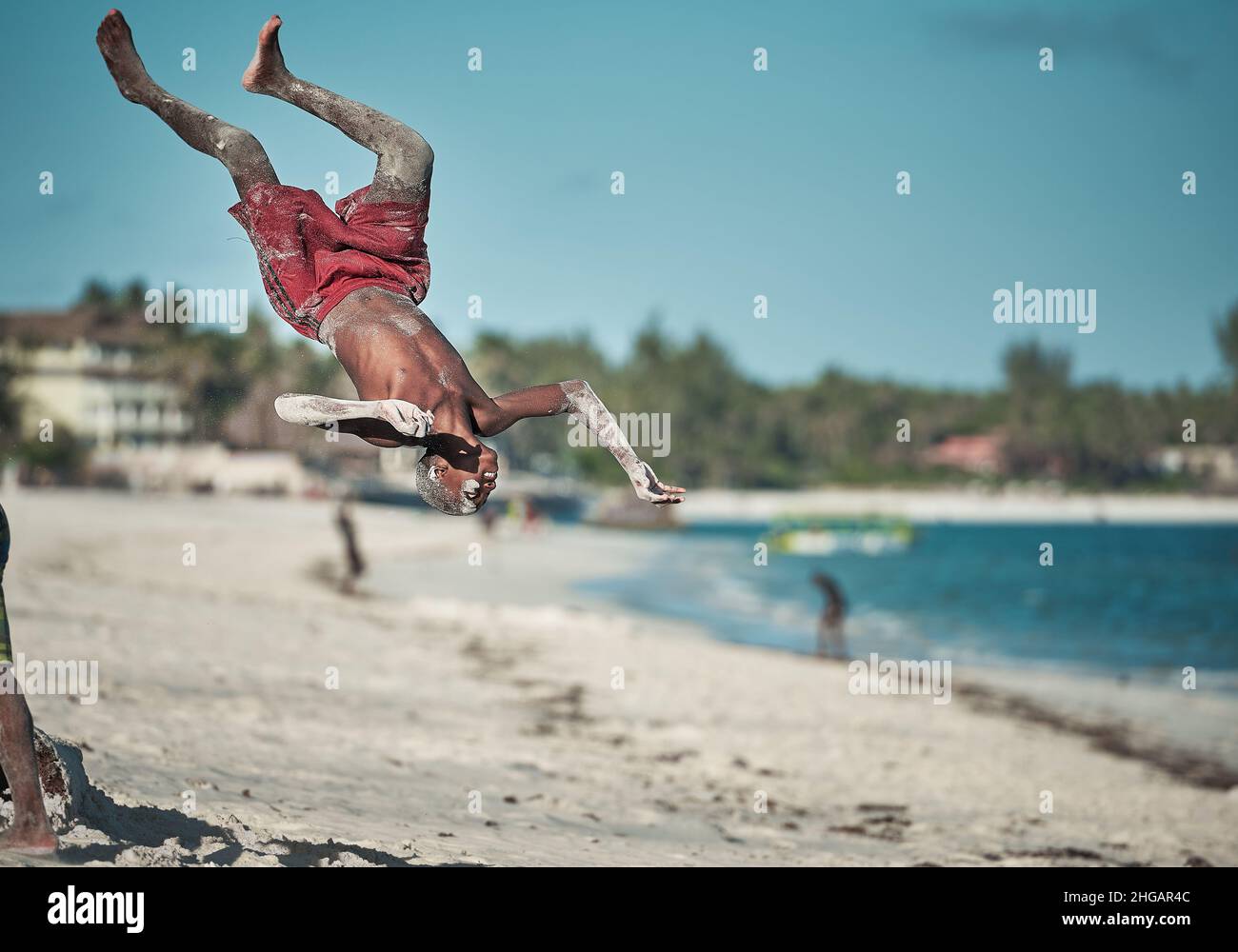 action acrobatioc jump of African young boy. Aerial rotation of am man ...