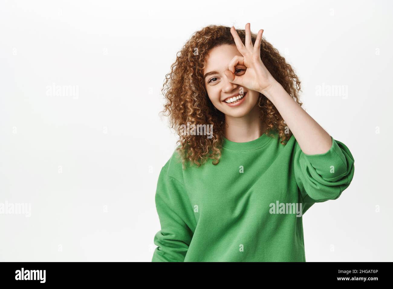 Portrait of smiling curly woman showing okay sign, ok gesture, zero ...