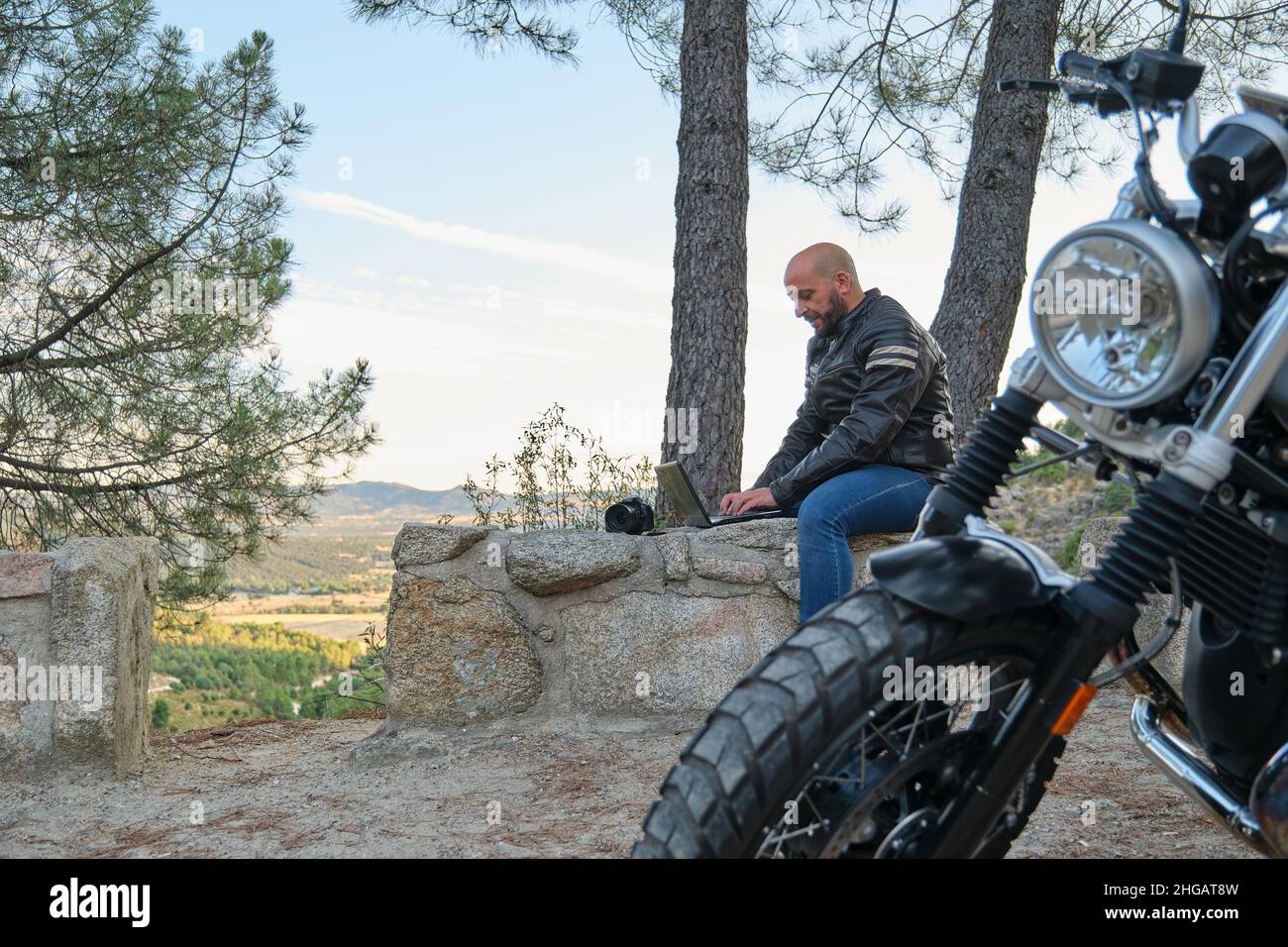 A digital nomana man working on his laptop while riding a motorcycle ...