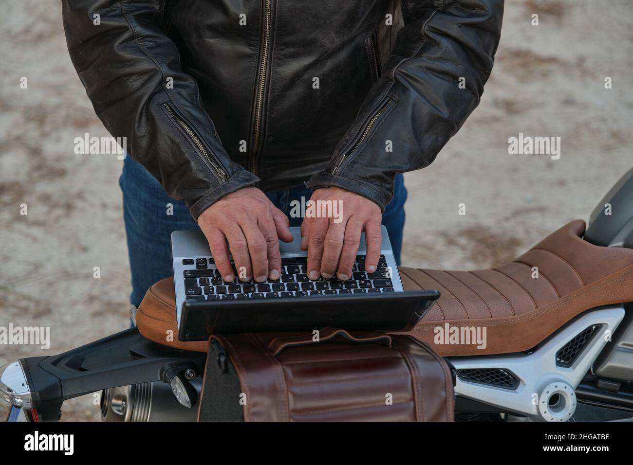 Unrecognizable man working on his laptop while riding a motorcycle ...