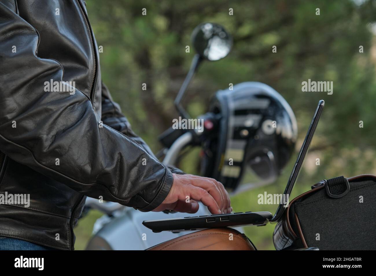 Side view of an unrecognizable man using a laptop while traveling with ...