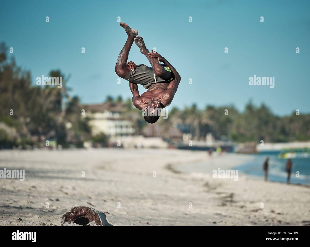 action acrobatioc jump of African young boy. Aerial rotation of am man ...