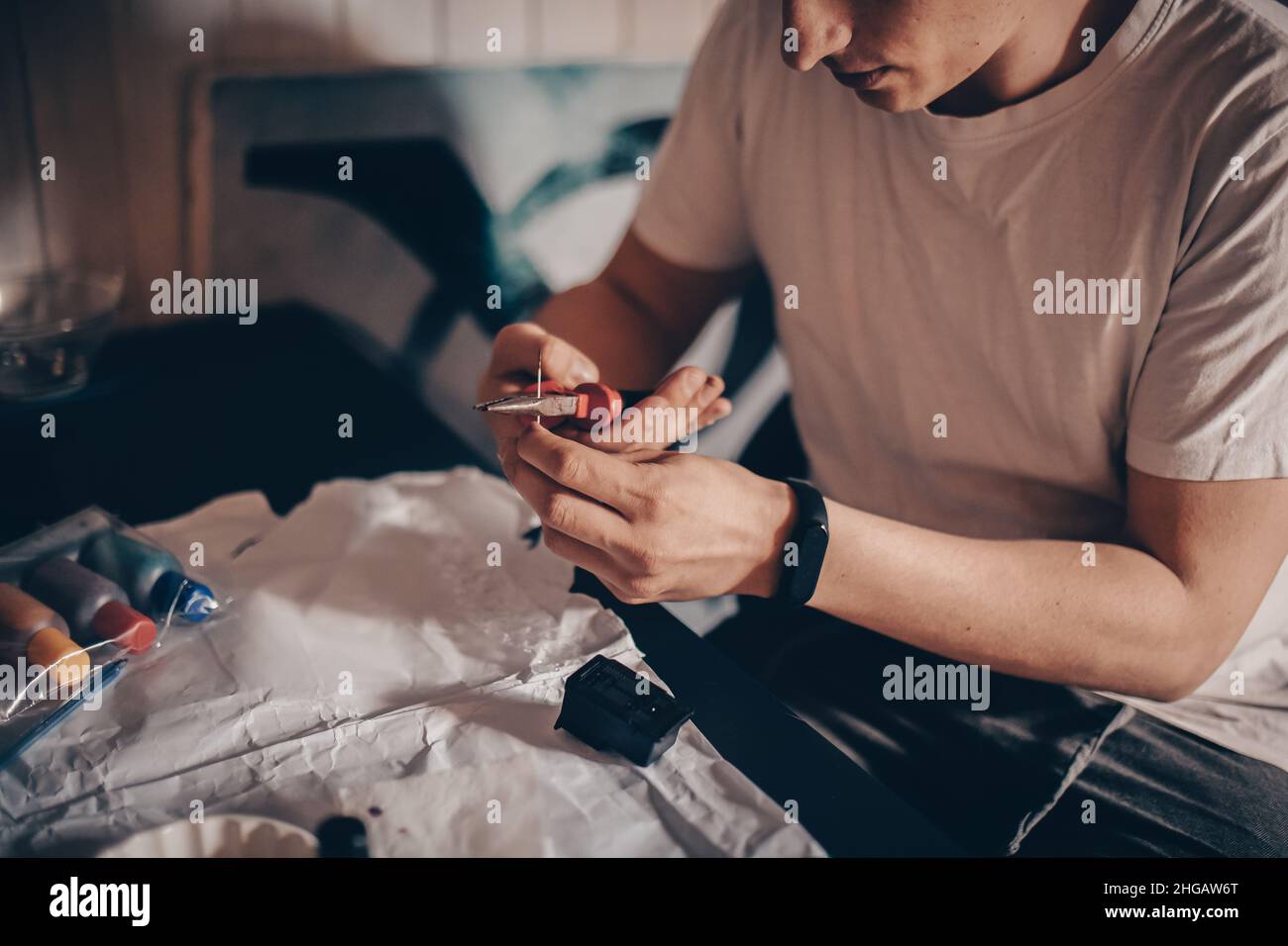 Male hands refill printer cartridge. The guy makes holes in the ...