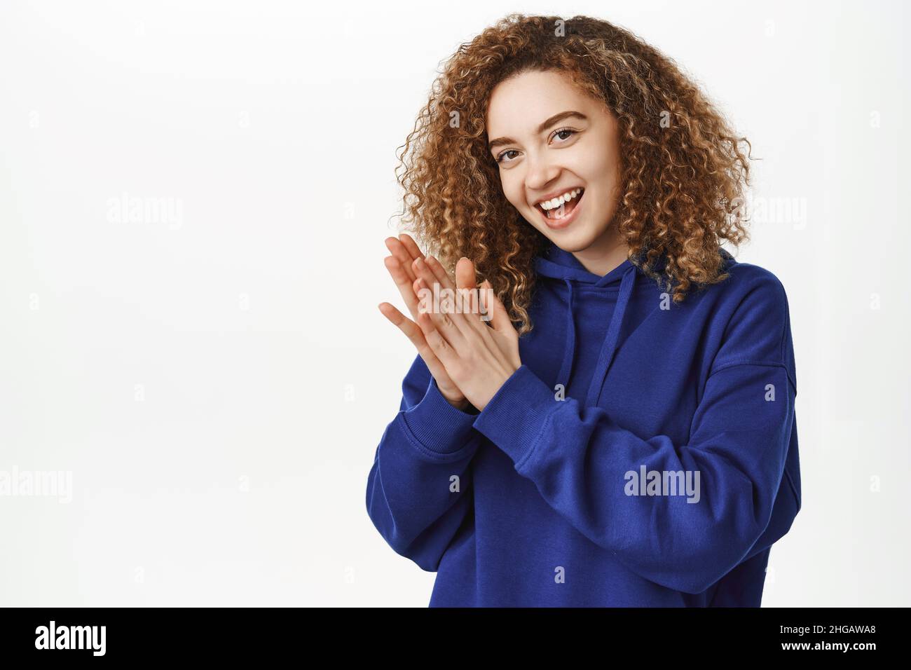 Portrait of stylish young curly woman, clapping hands, girl applause ...