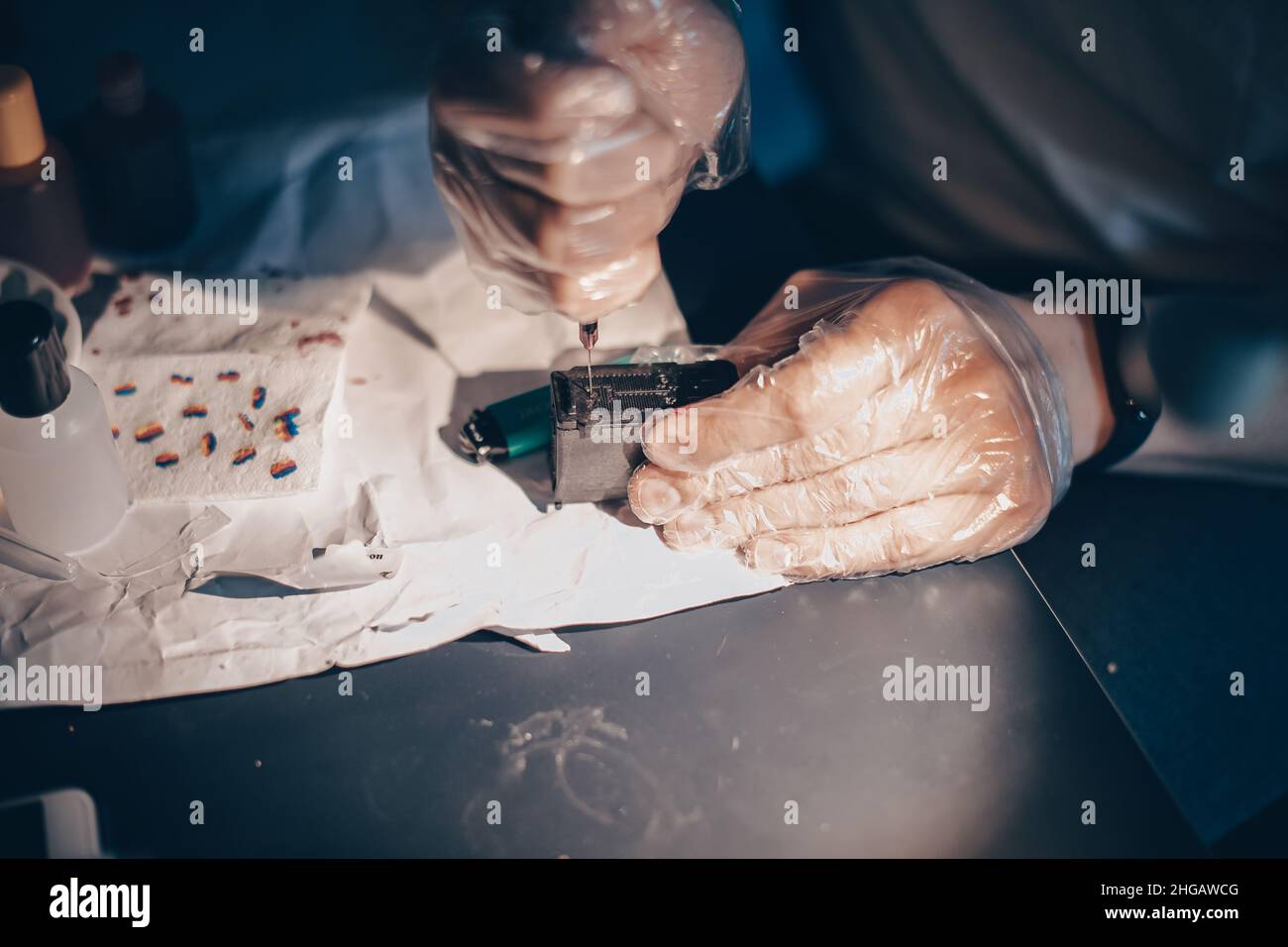 Male hands refill printer cartridge. The guy makes holes in the ...