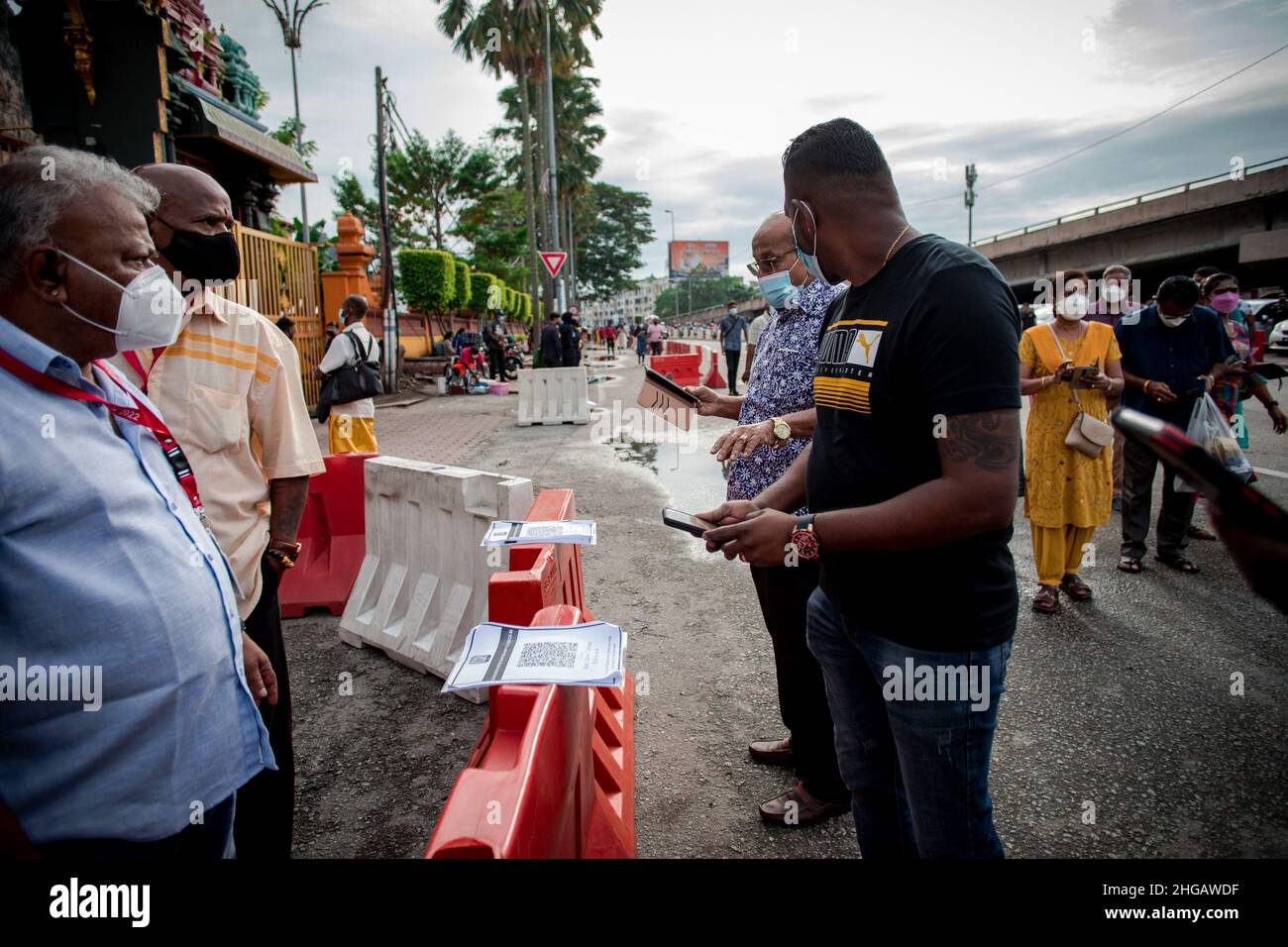 Hindu Devotees wearing face masks are seen scanning the 'MySejahtera ...
