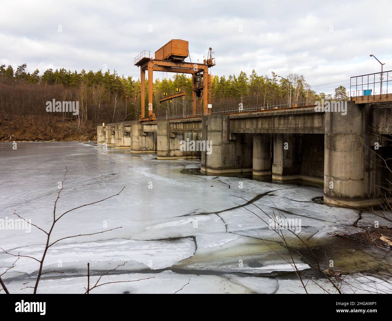 Old crumbling dam across the river, a crossing over the dam road ...