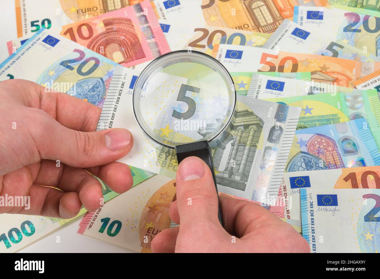 Hand magnifier, check banknotes, symbol photo counterfeit money, studio ...