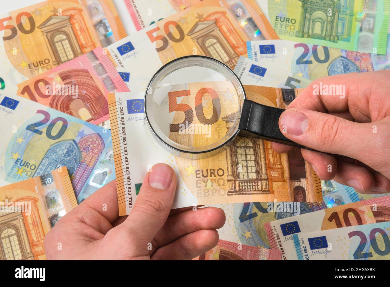 Hand magnifier, check banknotes, symbol photo counterfeit money, studio ...