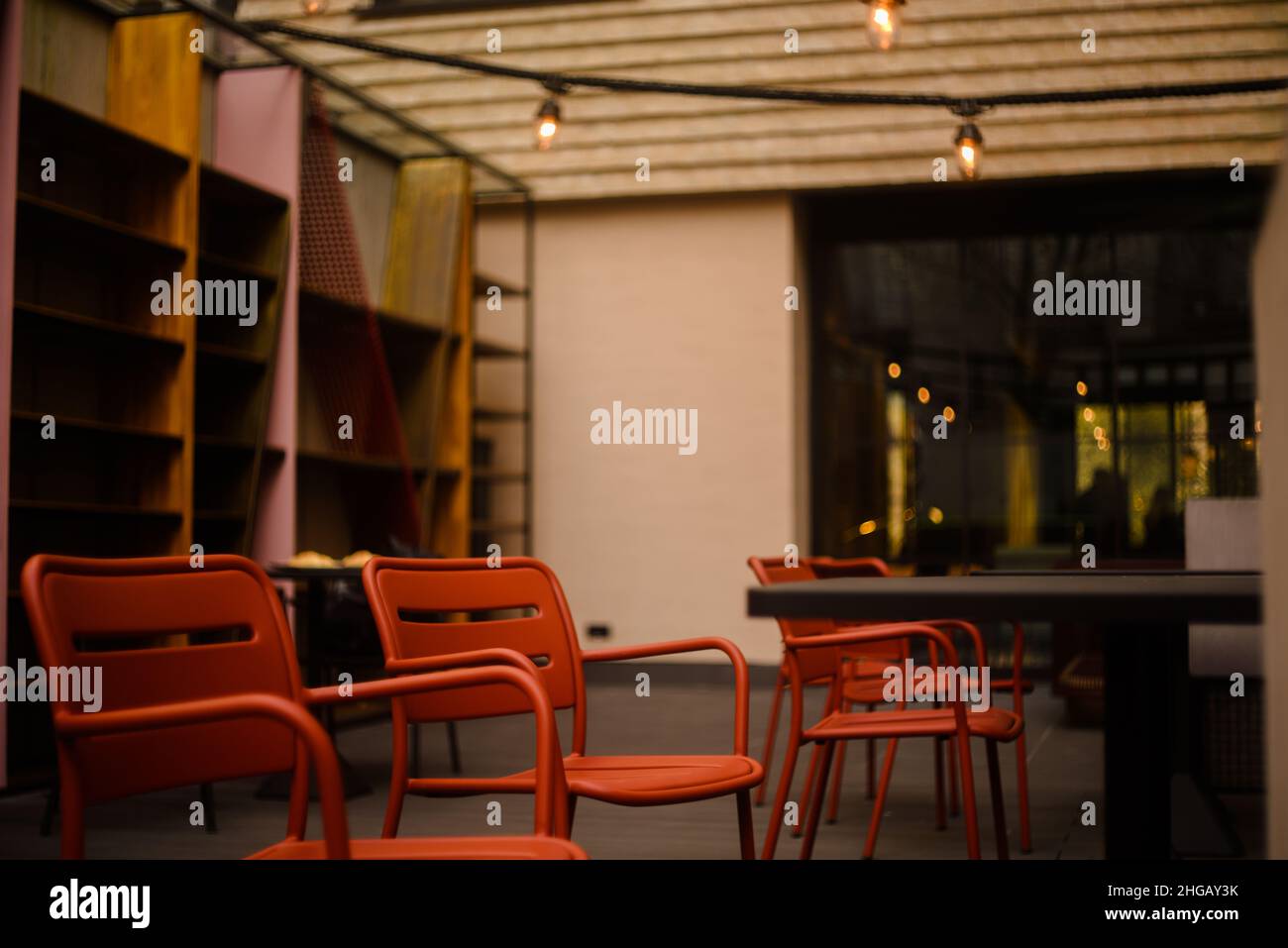 Street restaurant with red chairs and lights Stock Photo - Alamy