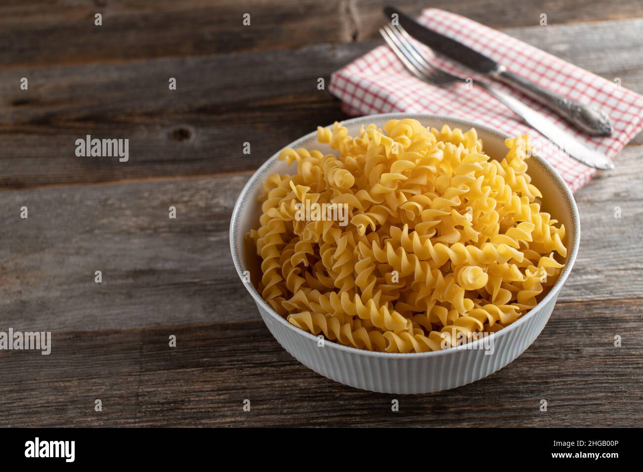 Fusilli raw and uncooked italian pasta in a rustic bowl isolated on ...